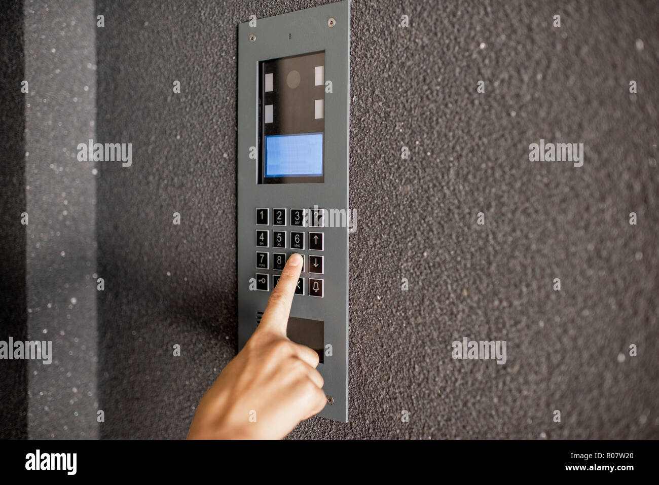 Close-up of intercome keyboard of residential building with finger ...