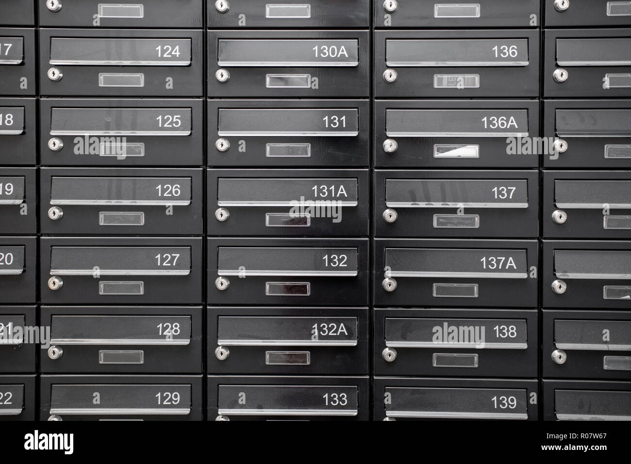 Traditional residential metal postboxes with apartment numbers at the ...