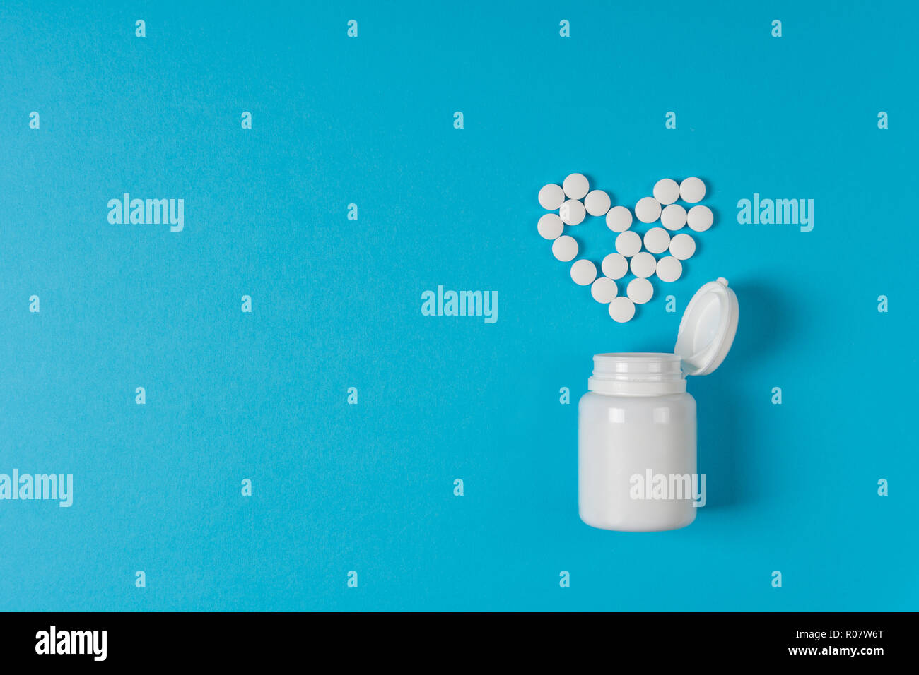 Medicine pills heart shaped on blue background. Heart protection. Drug ...