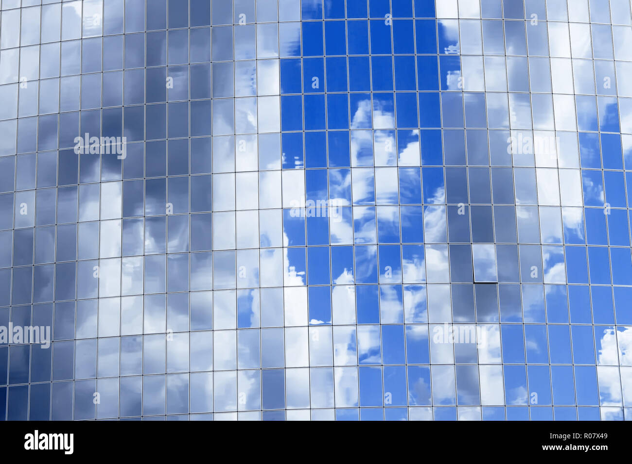 Blue sky with clouds reflected in glass windows of skyscrapers in the ...