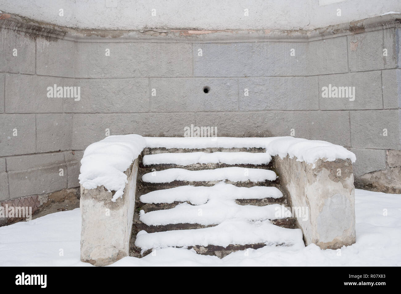 Snow-covered stone staircase near wall of old grey building with Stock ...
