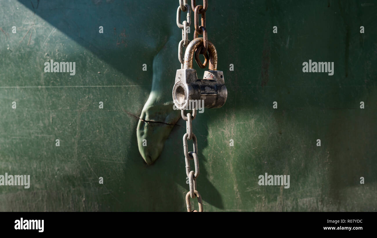 Old metal lock with a chain on green plastic background Stock Photo - Alamy