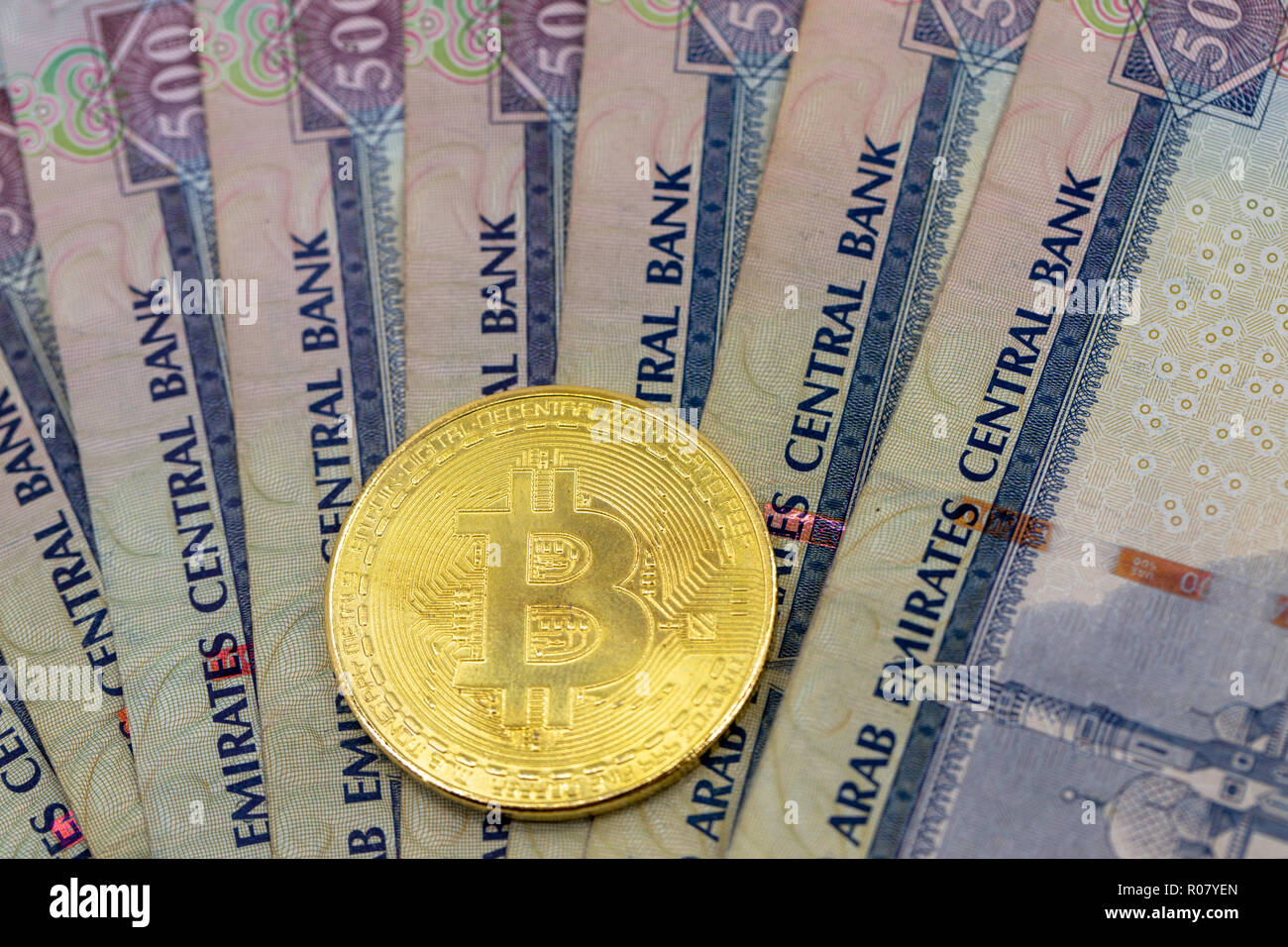 Bitcoin token on top of Dubai, dirham banknotes money. Cryptocurrency ...
