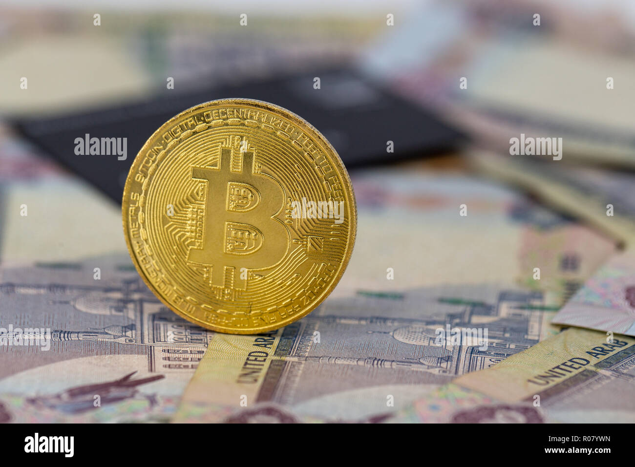 Bitcoin token on top of Dubai, dirham banknotes money with black credit ...