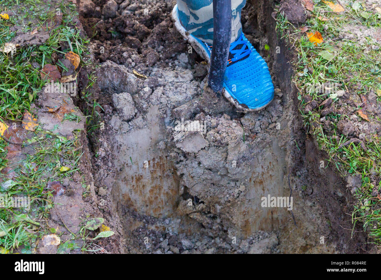 Man digging a ditch with a shovel in autumn Stock Photo - Alamy