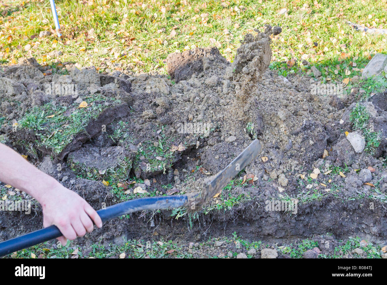 Man digging a ditch with a shovel in autumn Stock Photo - Alamy
