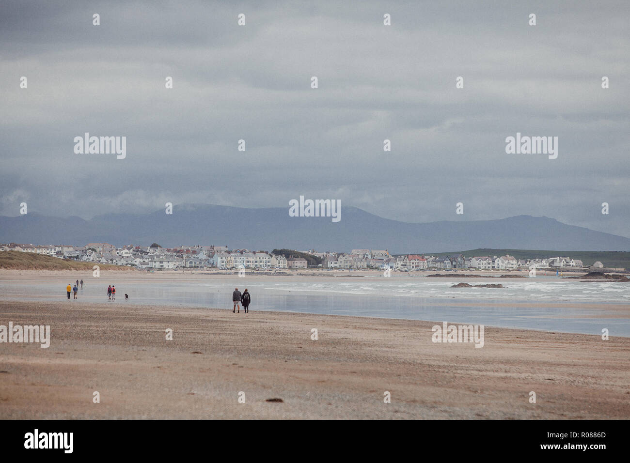 People walking along Cymyran beach, Rhosneigr, Anglesey, North Wales ...