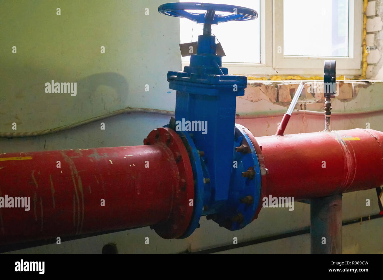 Big blue valve on the pipe painted in red color Stock Photo - Alamy