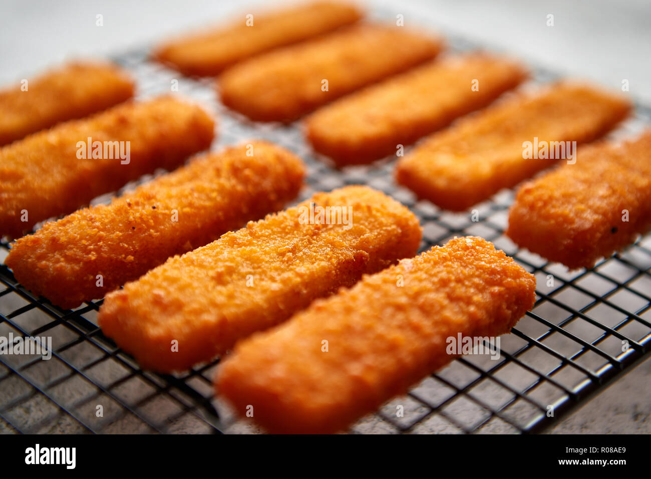 Rows of golden fried fresh fish fingers fillets Stock Photo - Alamy