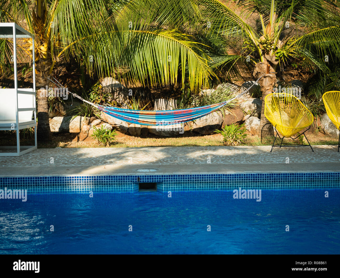 Poolside, blue water and hammock Stock Photo - Alamy