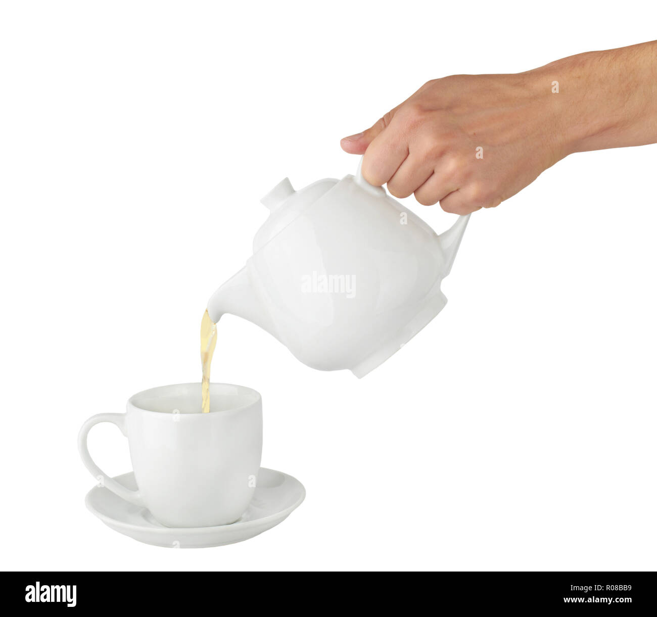 Teapot pouring tea into a cup on a white background Stock Photo - Alamy