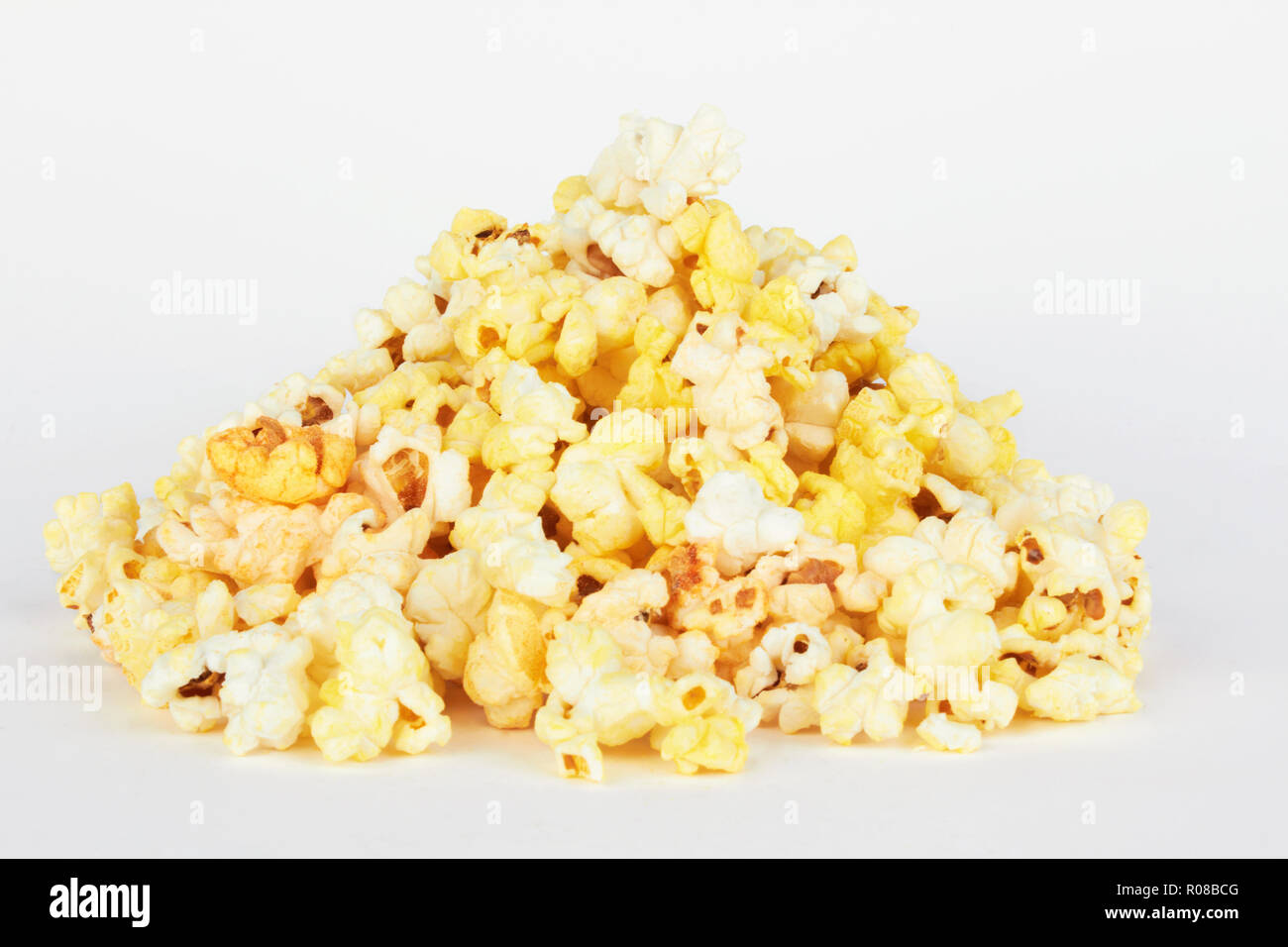 Salted popcorn grains on the white background Stock Photo - Alamy