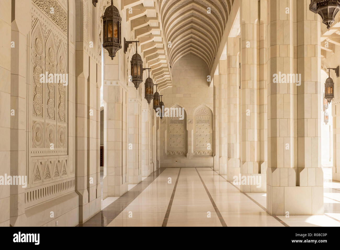 An arcade of arches with intricate lanterns and tilework in the Sultan ...