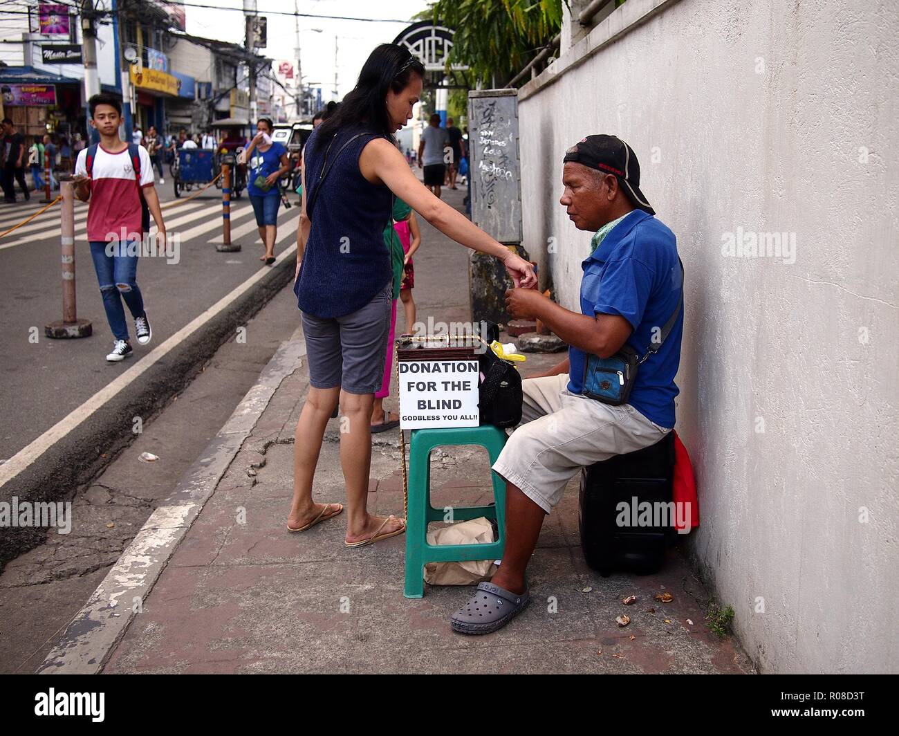 ANTIPOLO CITY, PHILIPPINES - OCTOBER 27, 2018: A woman gives loose ...