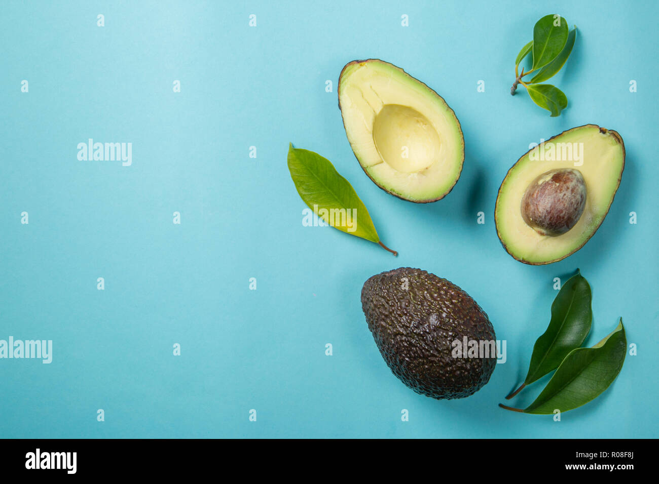 Slices of avocado on white background. Whole and half with leaves ...