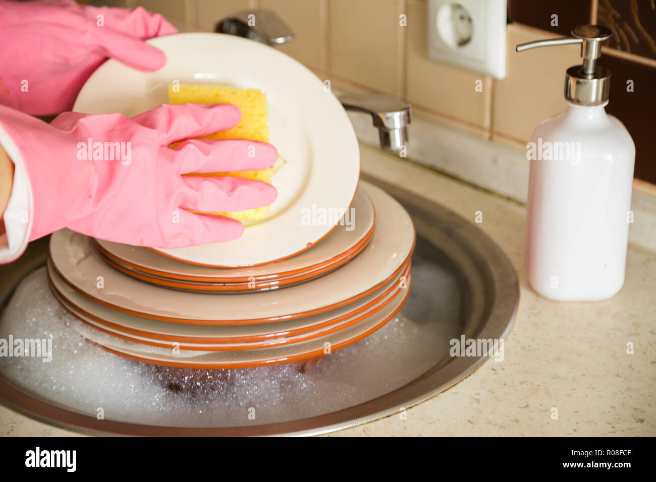 Hands doing the dishes in the sink, kitchen background Stock Photo - Alamy