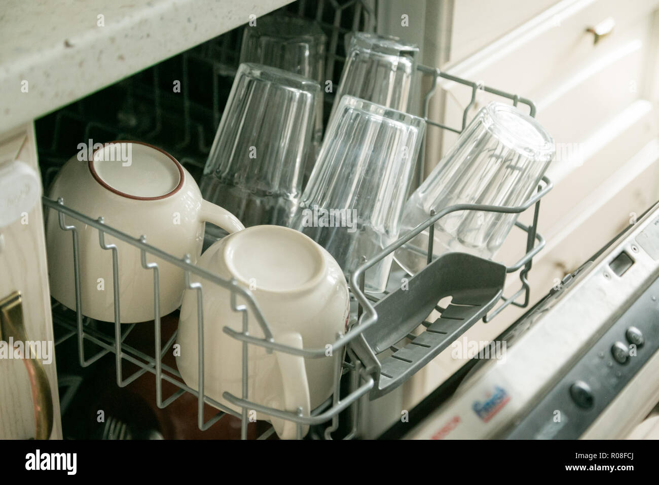 Dishwasher full with clean dishes in kitchen background, copy space ...