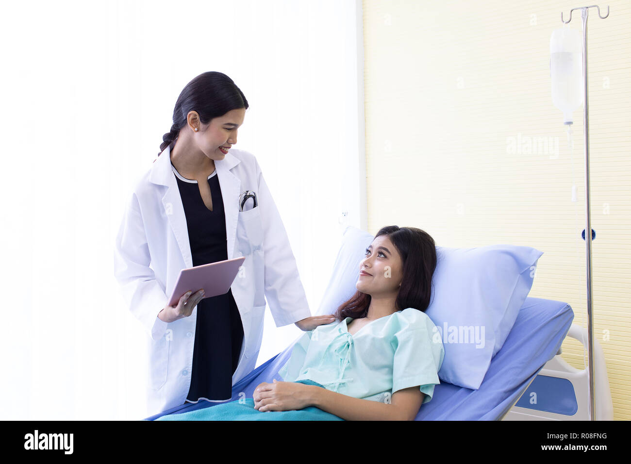 Asian Doctor make routine health check with patient in hospital ward ...