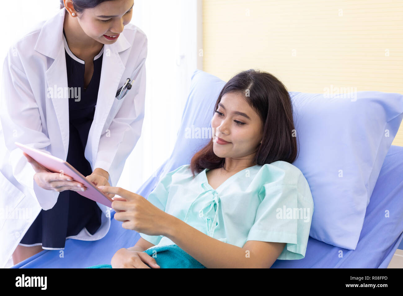 Asian Doctor make routine health check with patient in hospital ward ...