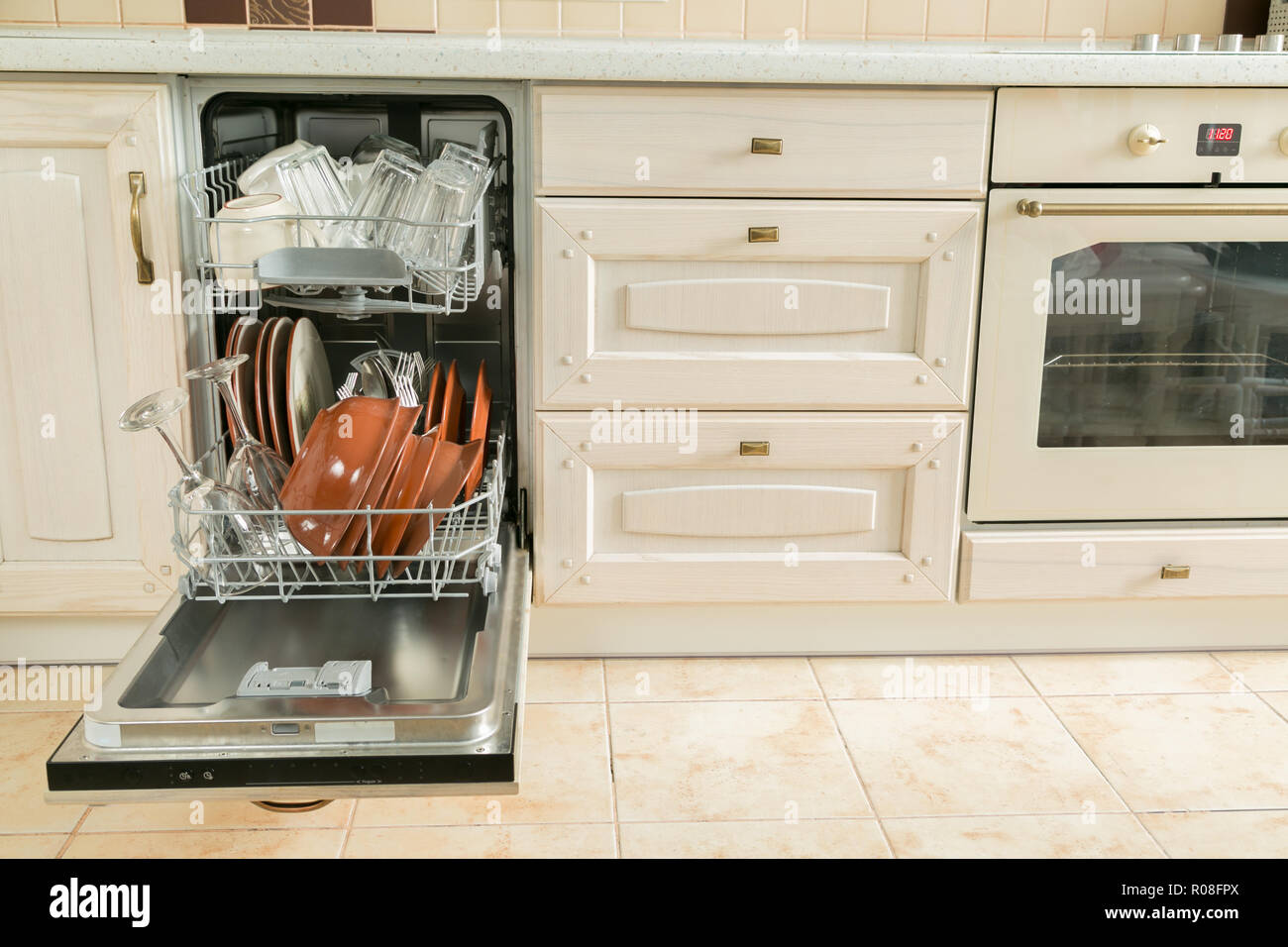 Dishwasher full with clean dishes in kitchen background, copy space ...