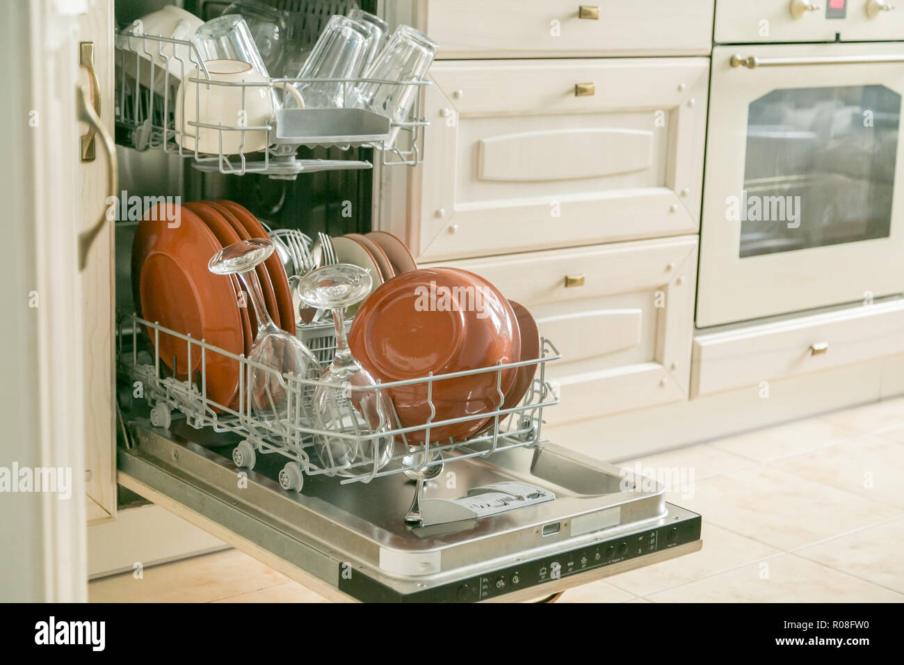 Dishwasher full with clean dishes in kitchen background, copy space ...