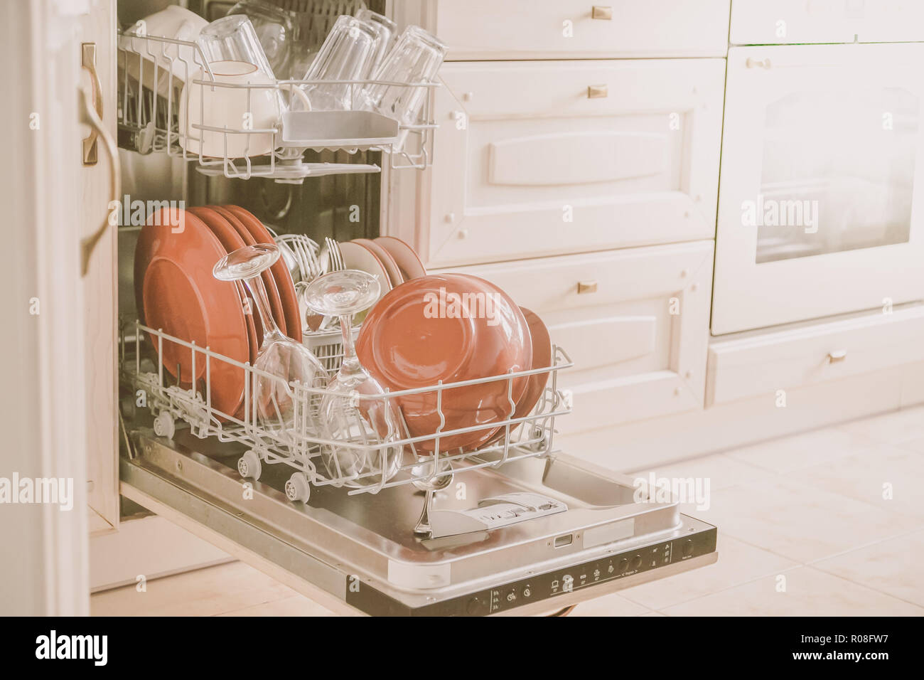 Dishwasher full with clean dishes in kitchen background, copy space ...