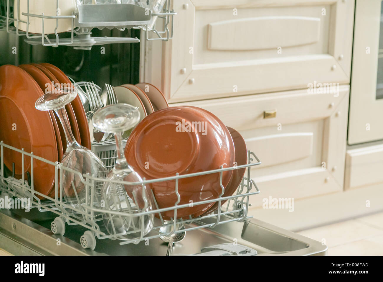 Dishwasher full with clean dishes in kitchen background, copy space ...