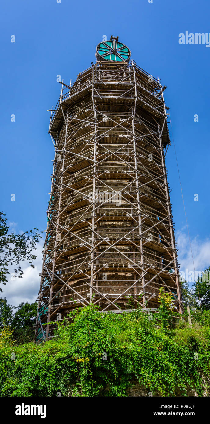 Vertical photo of ancient tower. The tower has wooden scaffolding and ...