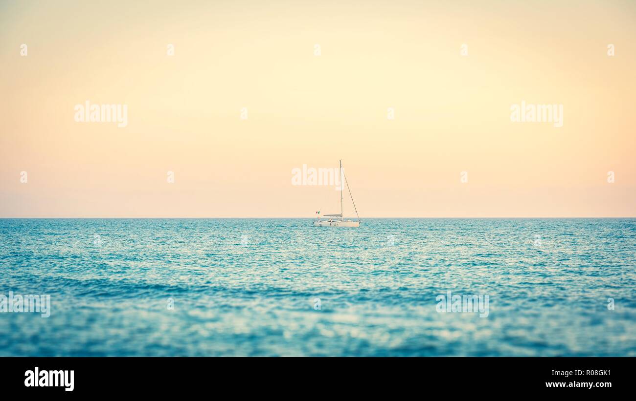 Horizontal photo with small ship. Boat has white color and high mast ...