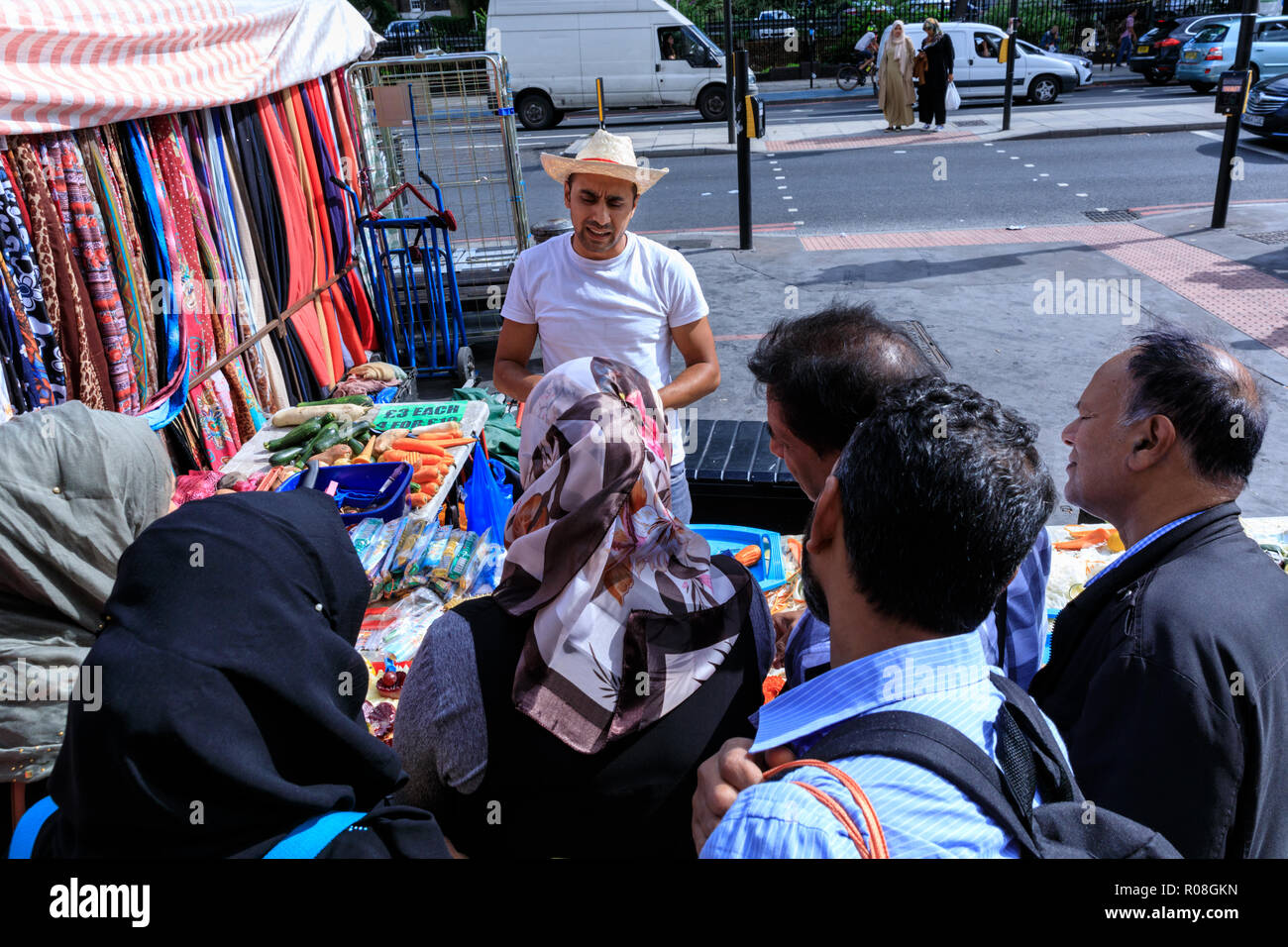Street scene East London, Whitechapel Market trader demonstrating food ...