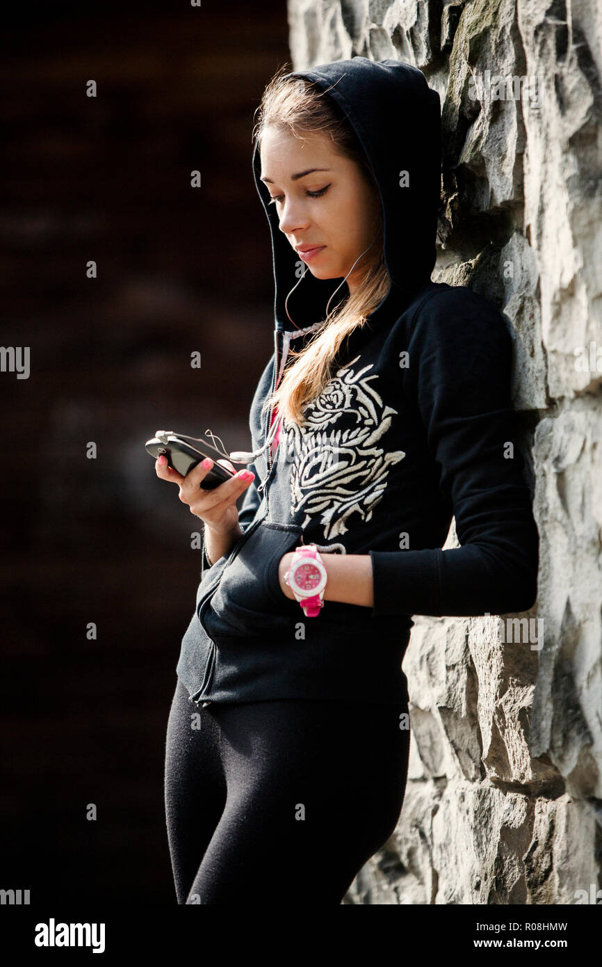 Woman setting mobile device before workout Stock Photo - Alamy