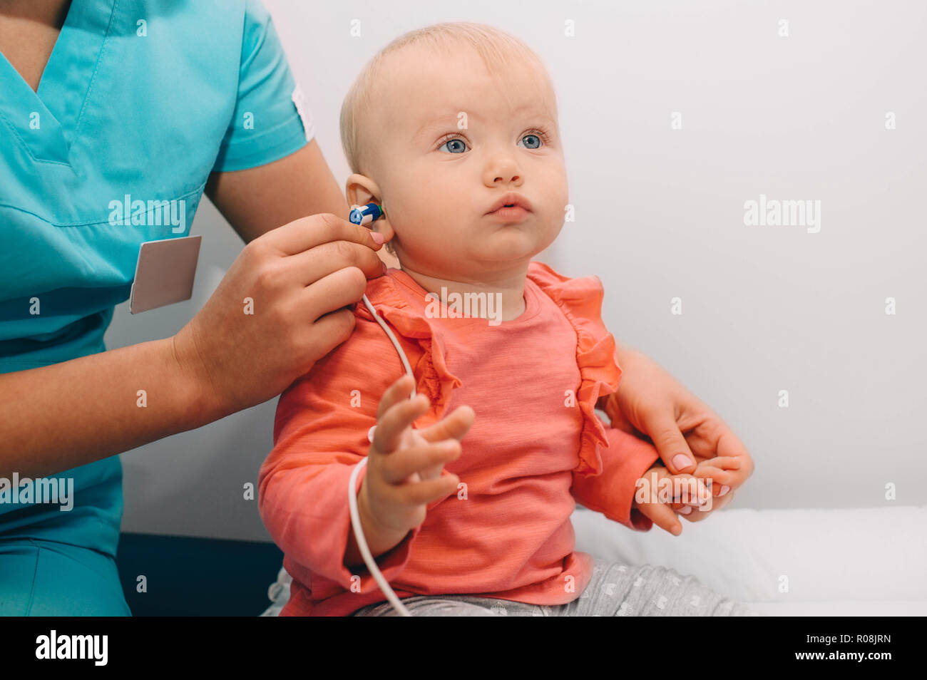 doctor check a baby girl's ears. Little baby having hearing test ...