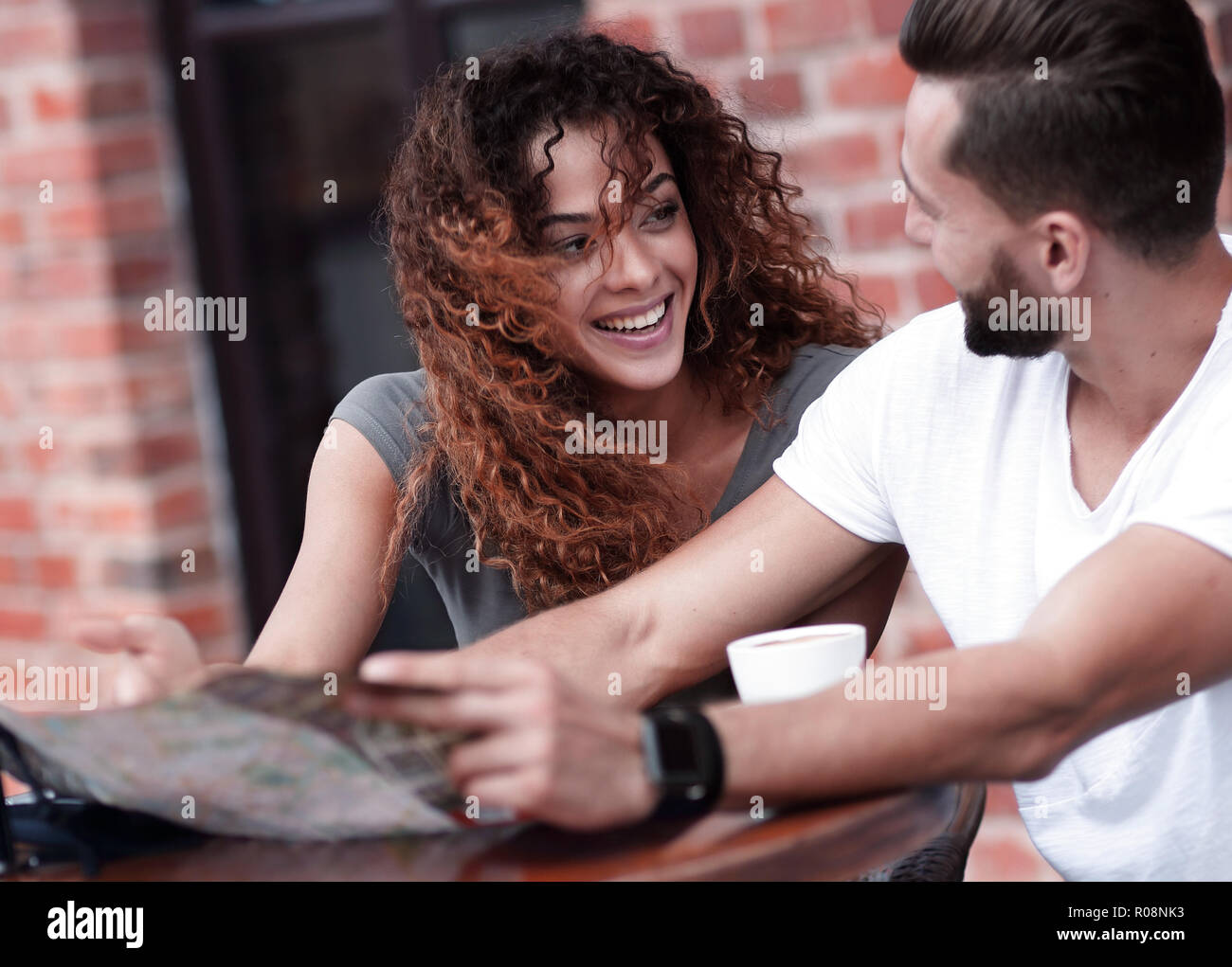 Young tourists having coffee at cafe and reading map Stock Photo - Alamy