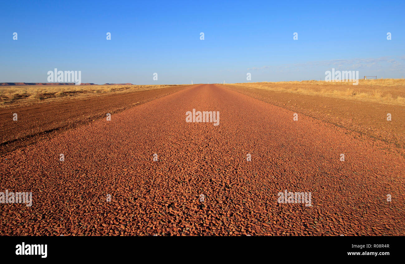 Outback Australian highway in Western Queensland with blue sky and red ...