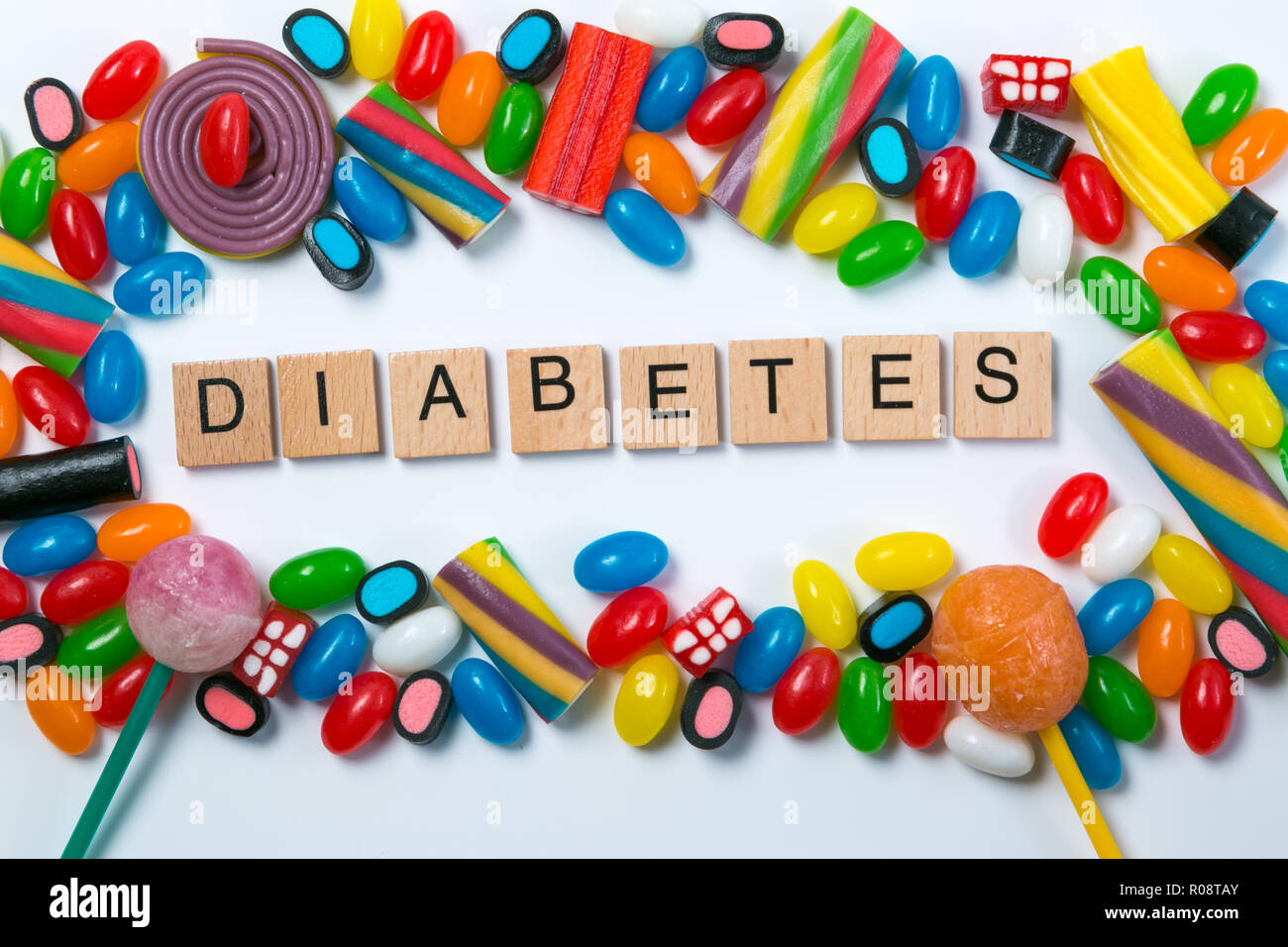 Diabetes concept - selection of candy on white background, top view ...
