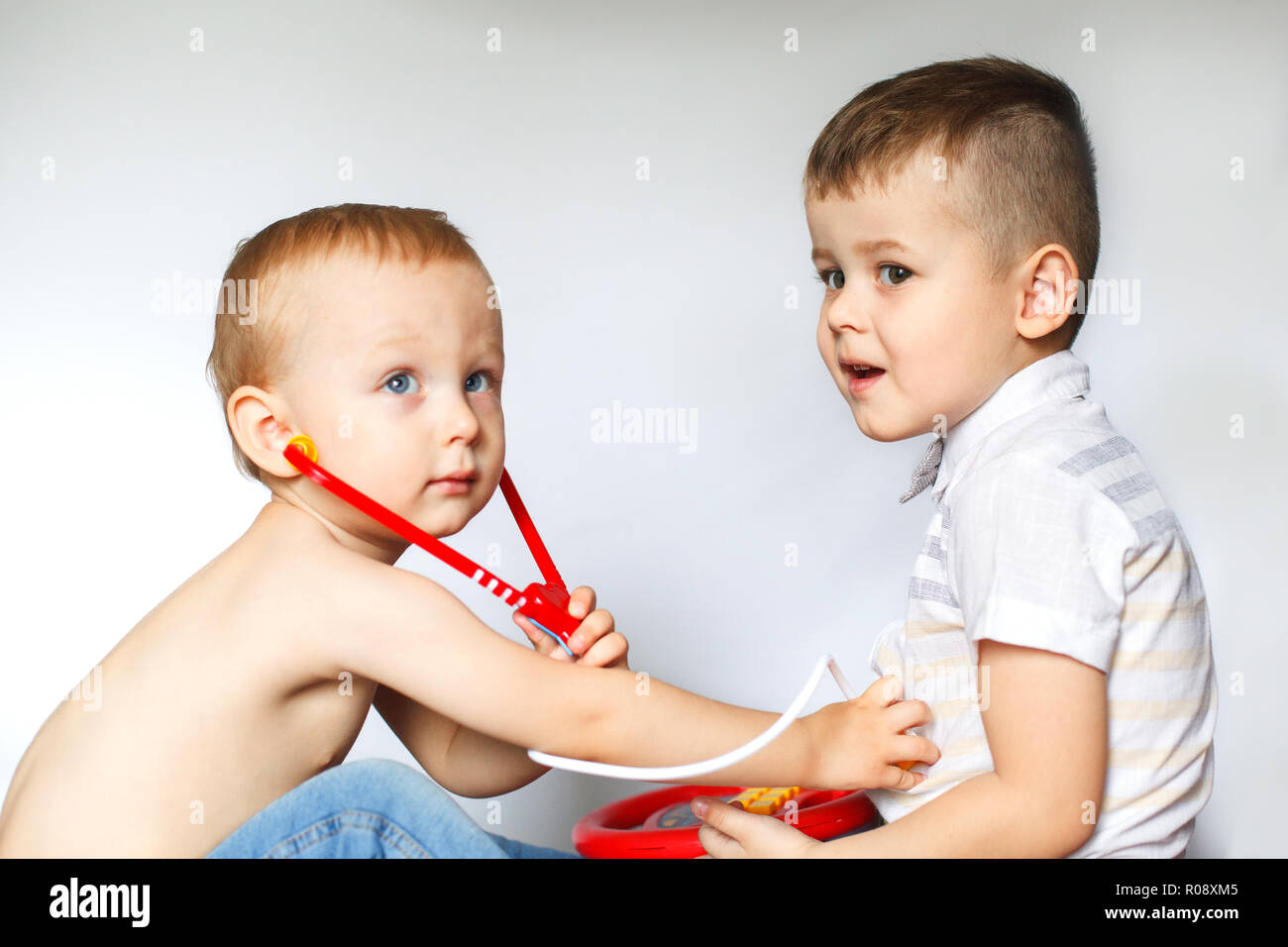 Children playing doctor and patient. Two little boys using stethoscope ...