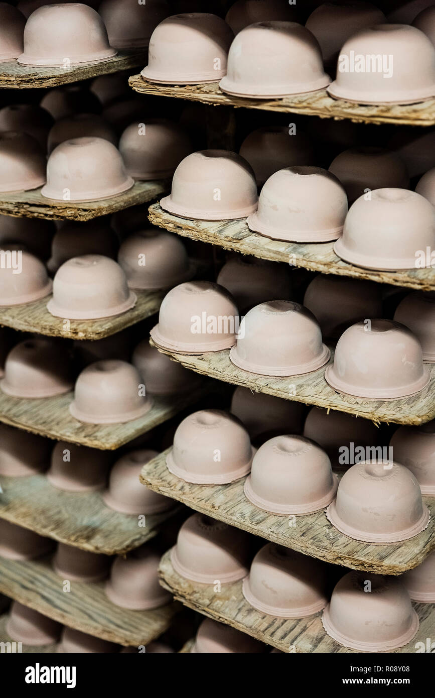 Unfinished clay cups ready for glazing after being fired in the kiln ...