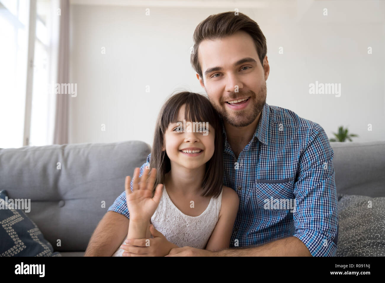 Father and daughter have video call sitting on couch Stock Photo - Alamy