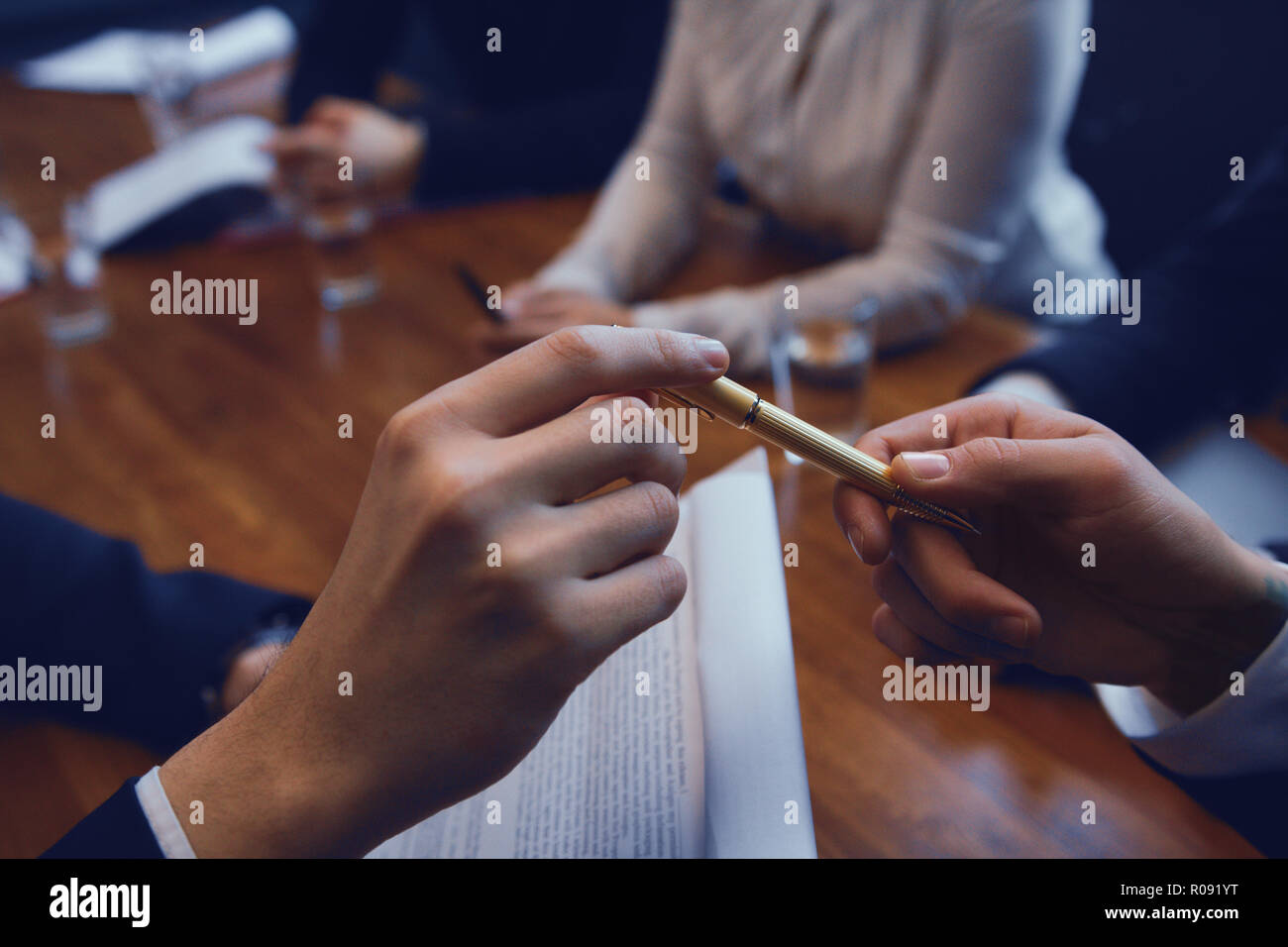 Businessman passes pen to partner to sign agreement. Having business ...