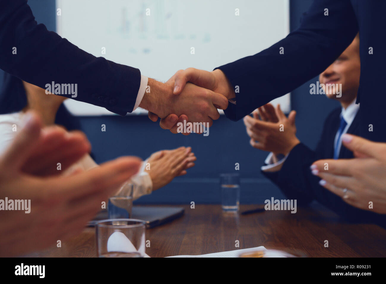 Two business partners shaking hands during conference. Agreed details ...