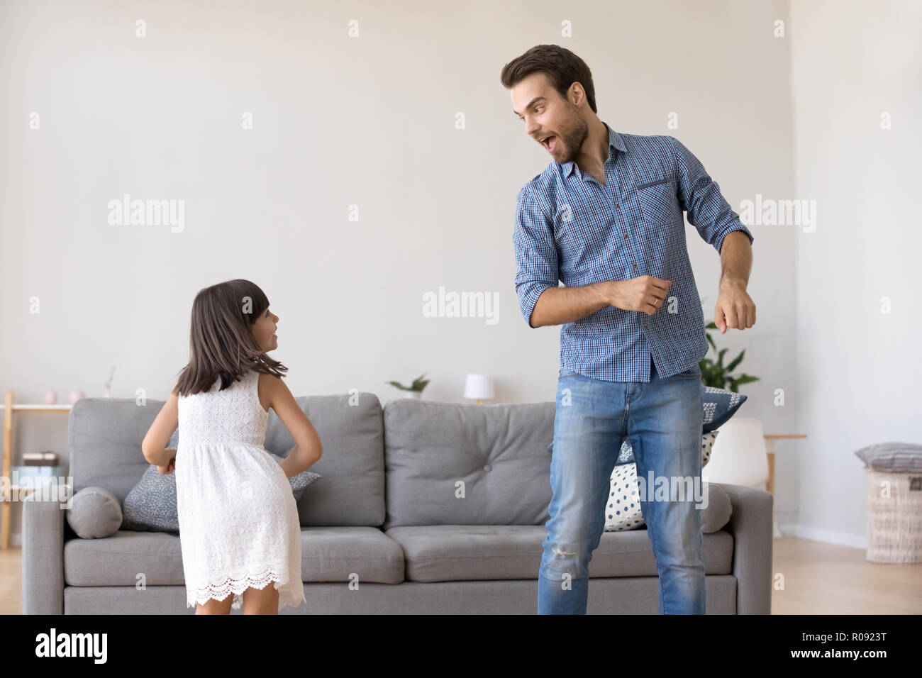 Father and daughter dancing together in living room Stock Photo - Alamy