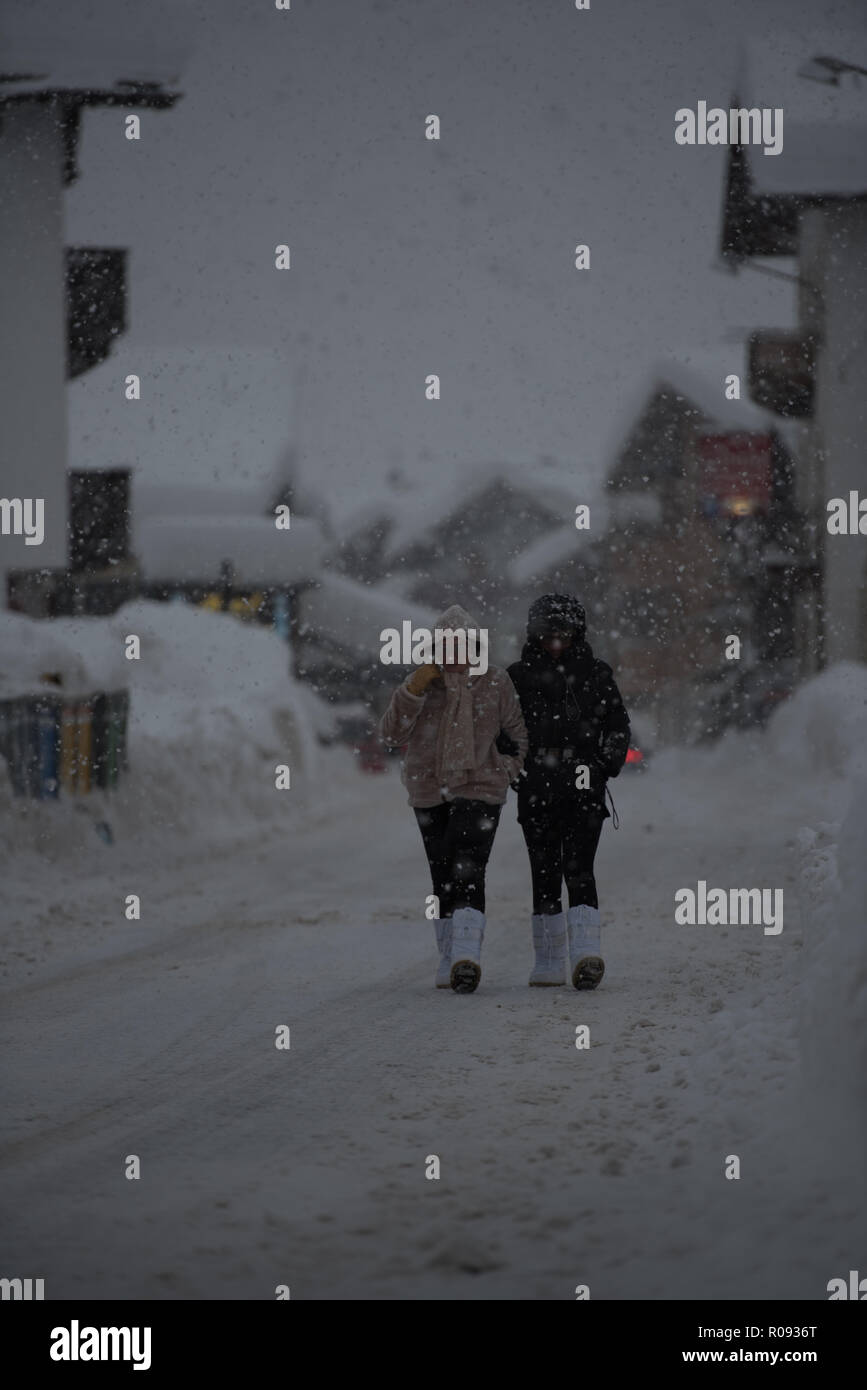 People in ski resort village covered by snow in Europe during winter ...