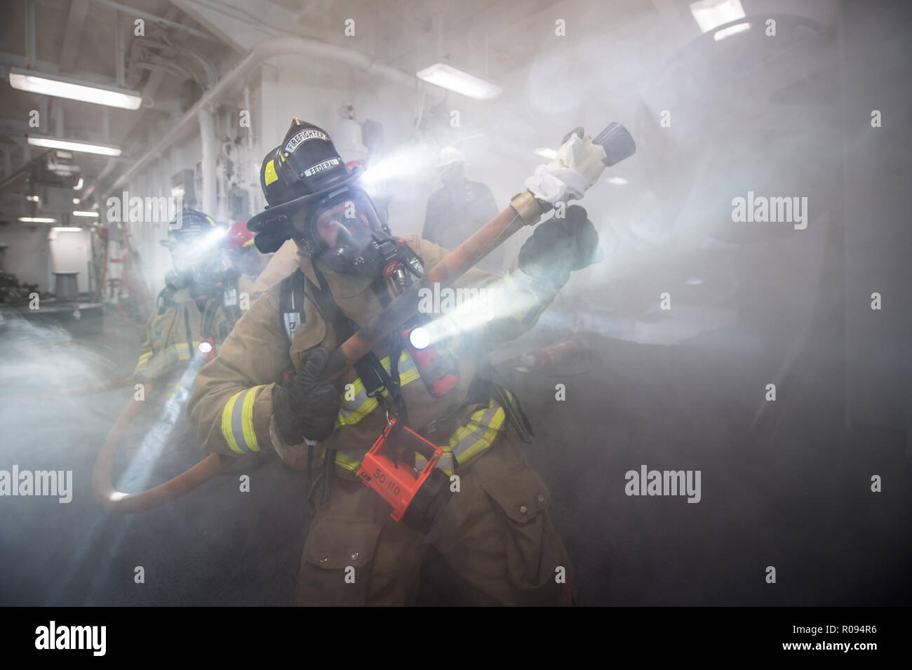 U.S. Sailors and members of Federal Fire San Diego fight a simulated ...