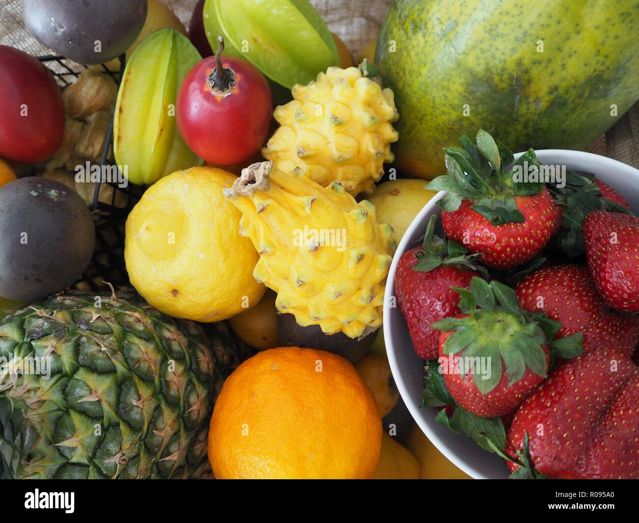 Various colorful tropical fruit, selection in wooden tray over, top ...