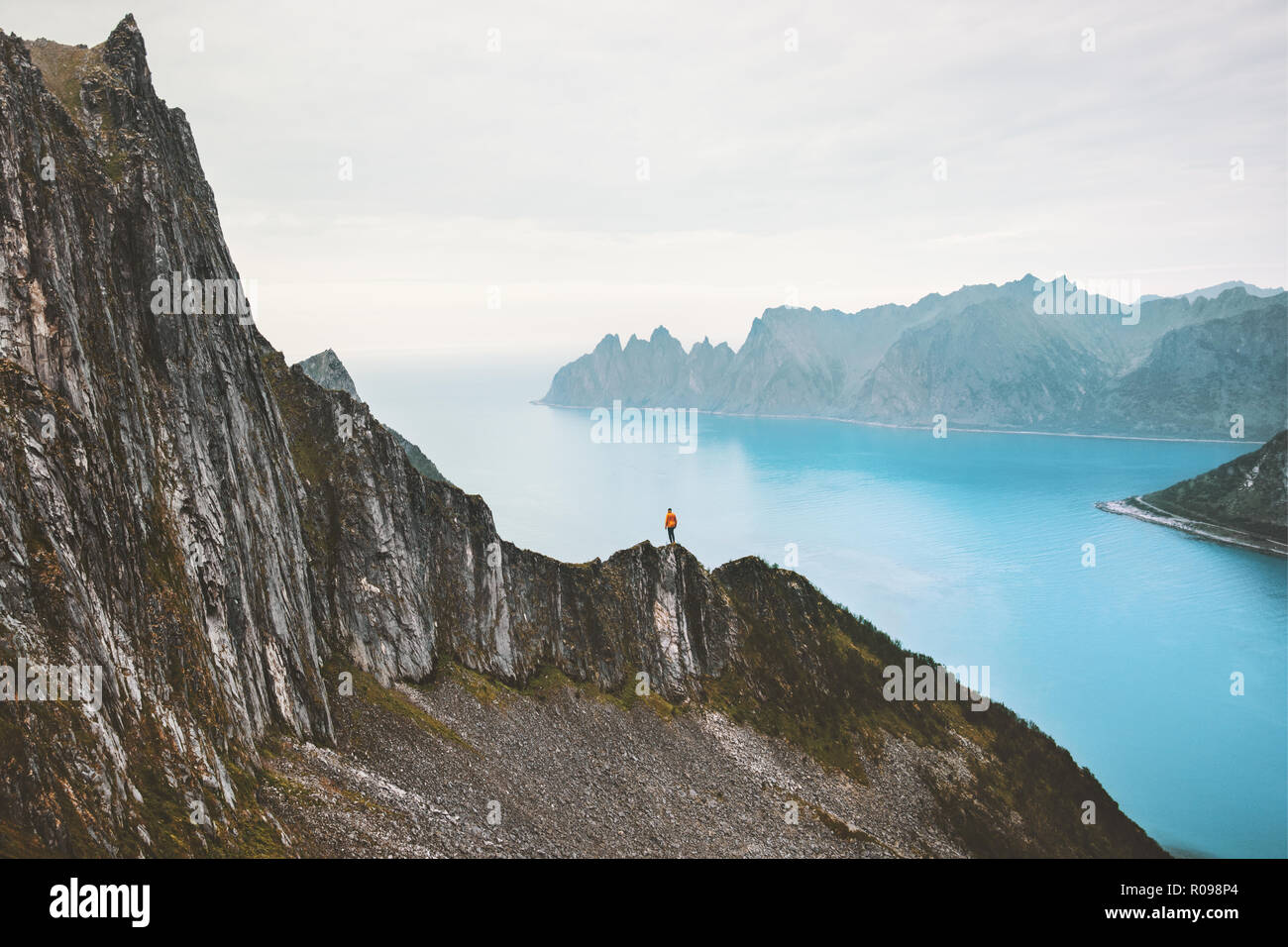 Travel Norway vacations man standing alone on cliff above fjord ...