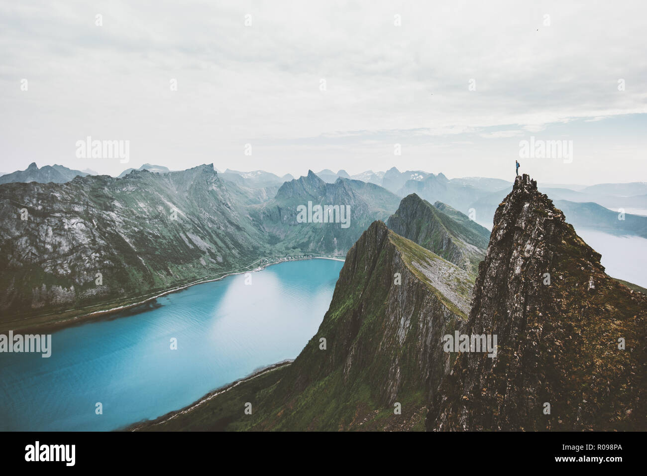 Norway mountain travel man standing on cliff edge above fjord adventure ...