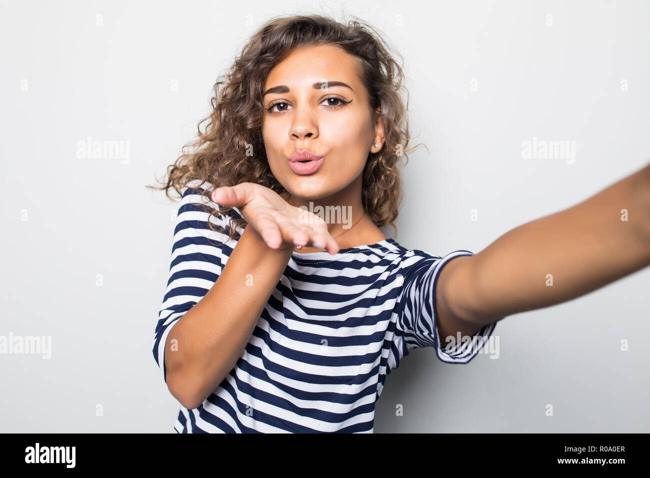 Portrait of a young mixed race mulatto woman taking selfie with mobile ...