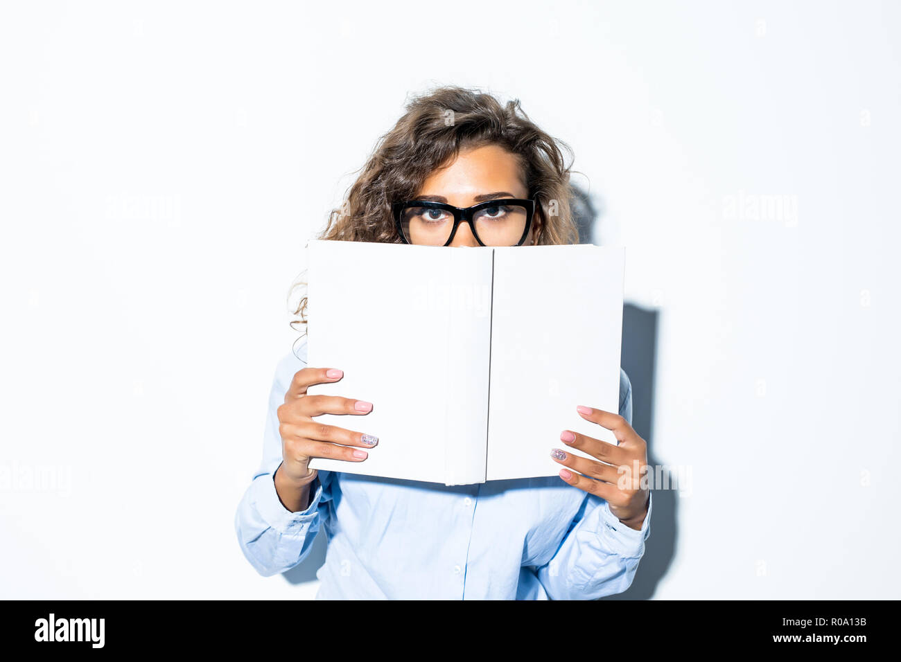 Young businesswoman looking over book cover isolated on white ...