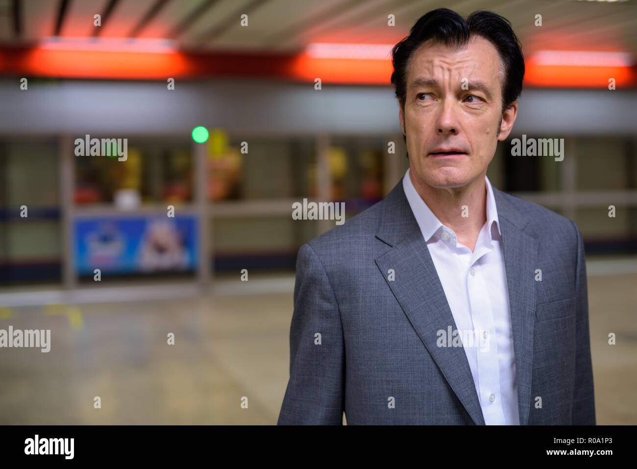 Portrait of mature handsome businessman in train station Stock Photo ...
