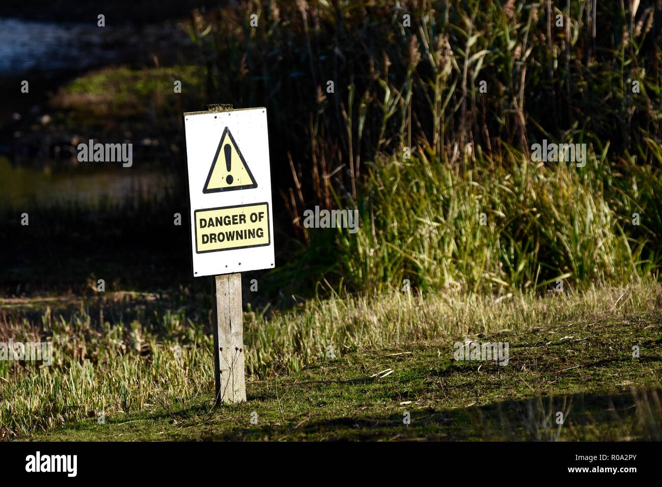 Danger of drowning sign post next to lake Stock Photo - Alamy
